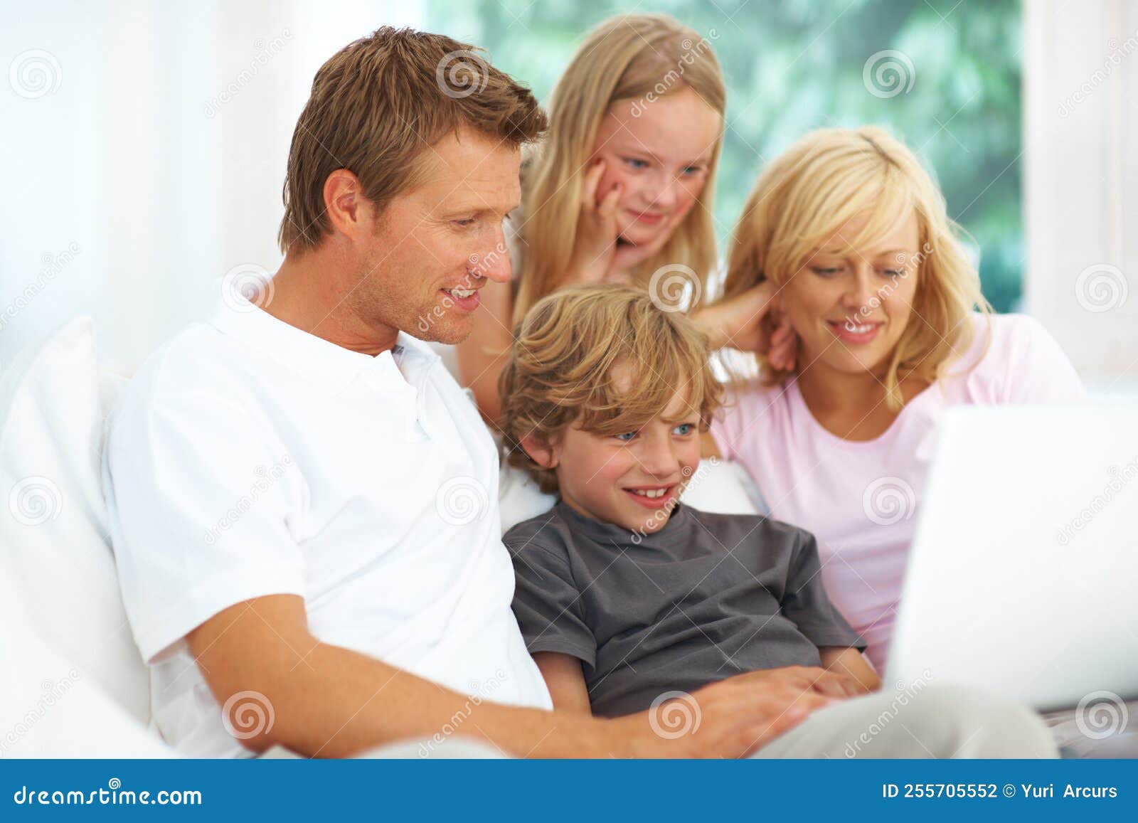 Exploring Technology Together. Happy Young Family Using a Laptop ...