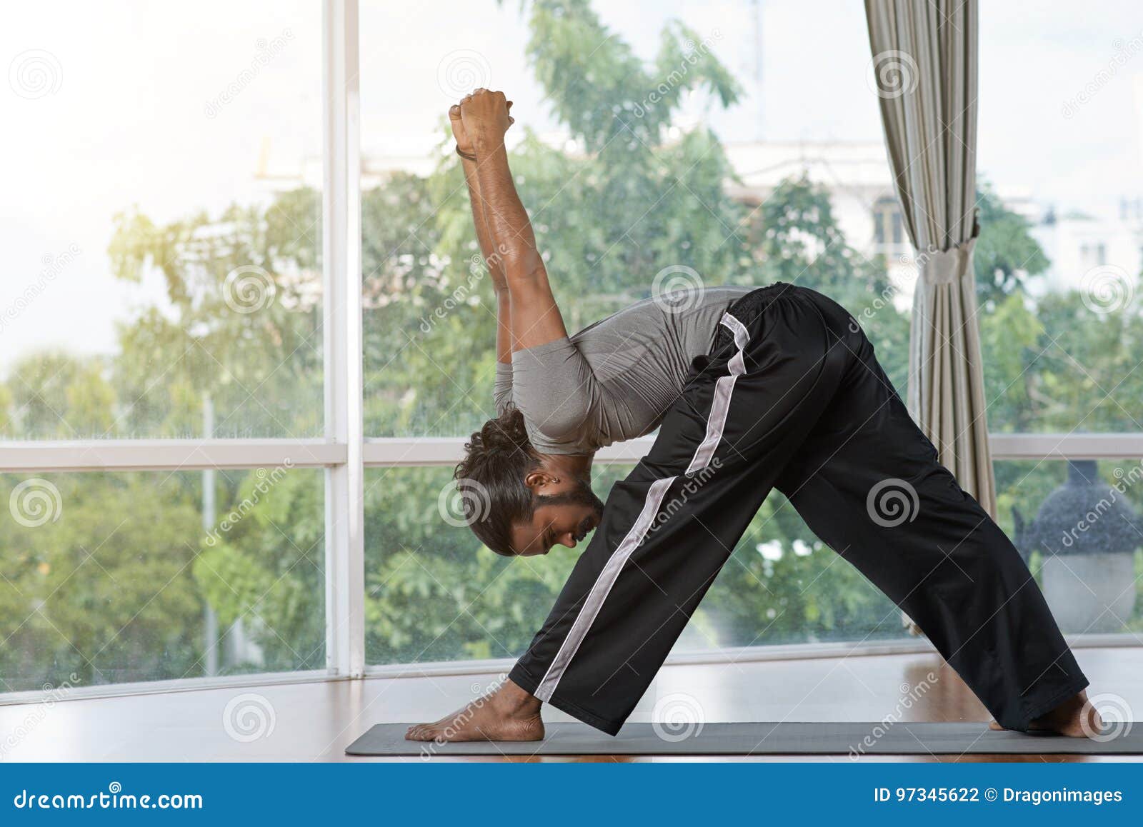Extending triangle pose stock photo. Image of flexible - 97345622