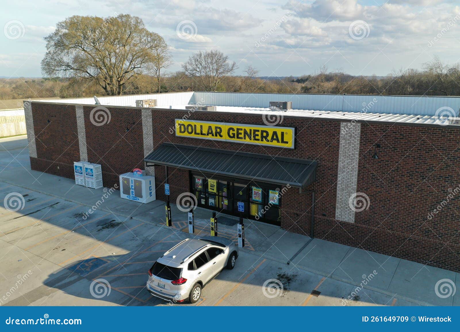 Exterior of a Dollar General, with a Car in Front and Trees in the ...