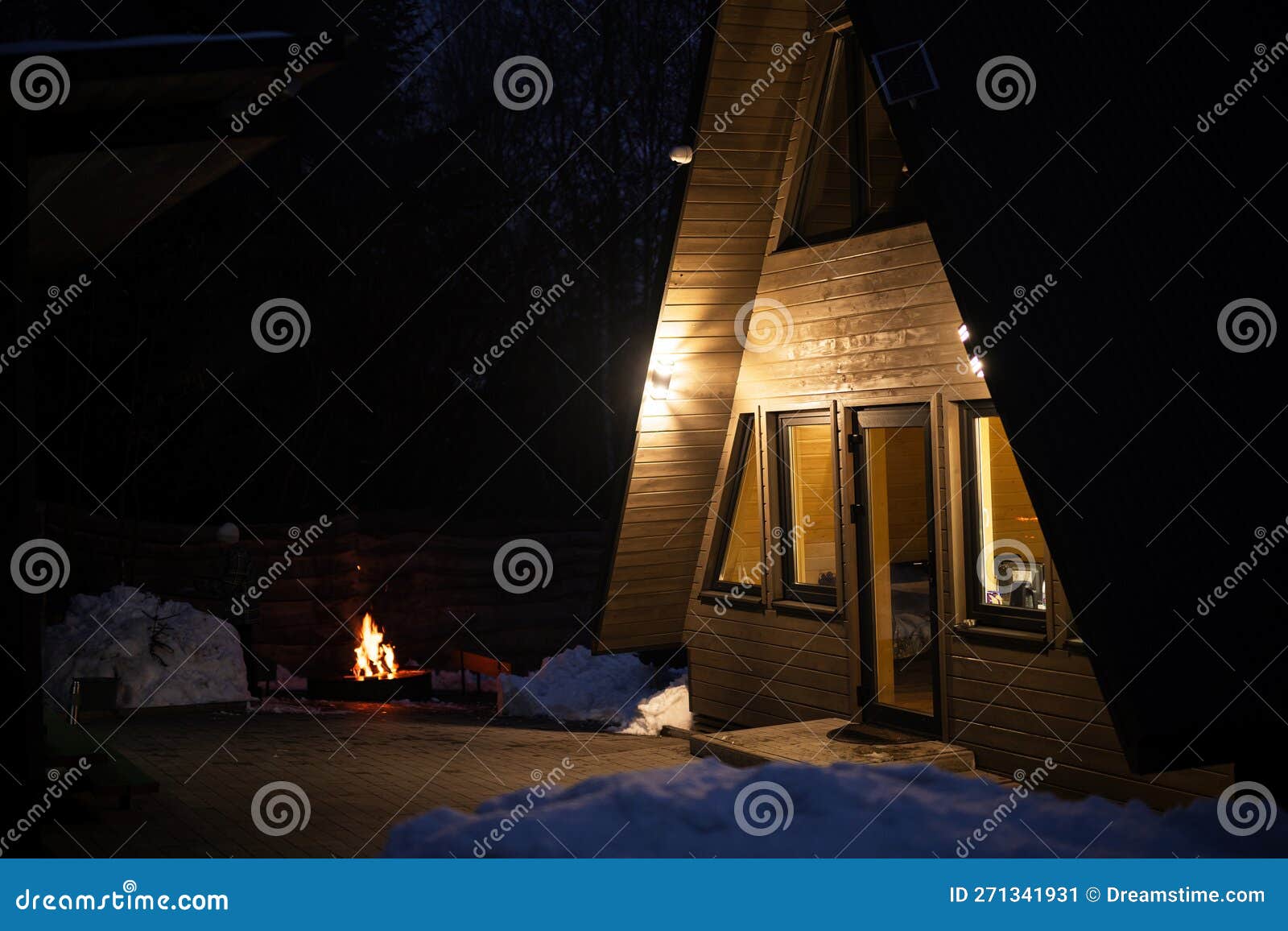 Exterior at Dusk of Modern Triangle Log Cabin in the Mountains with ...