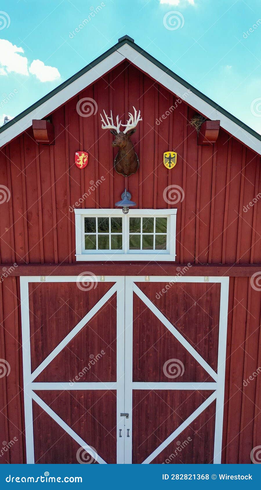 Exterior View of a Red and White Barn with a Mounted Deer Head on it ...