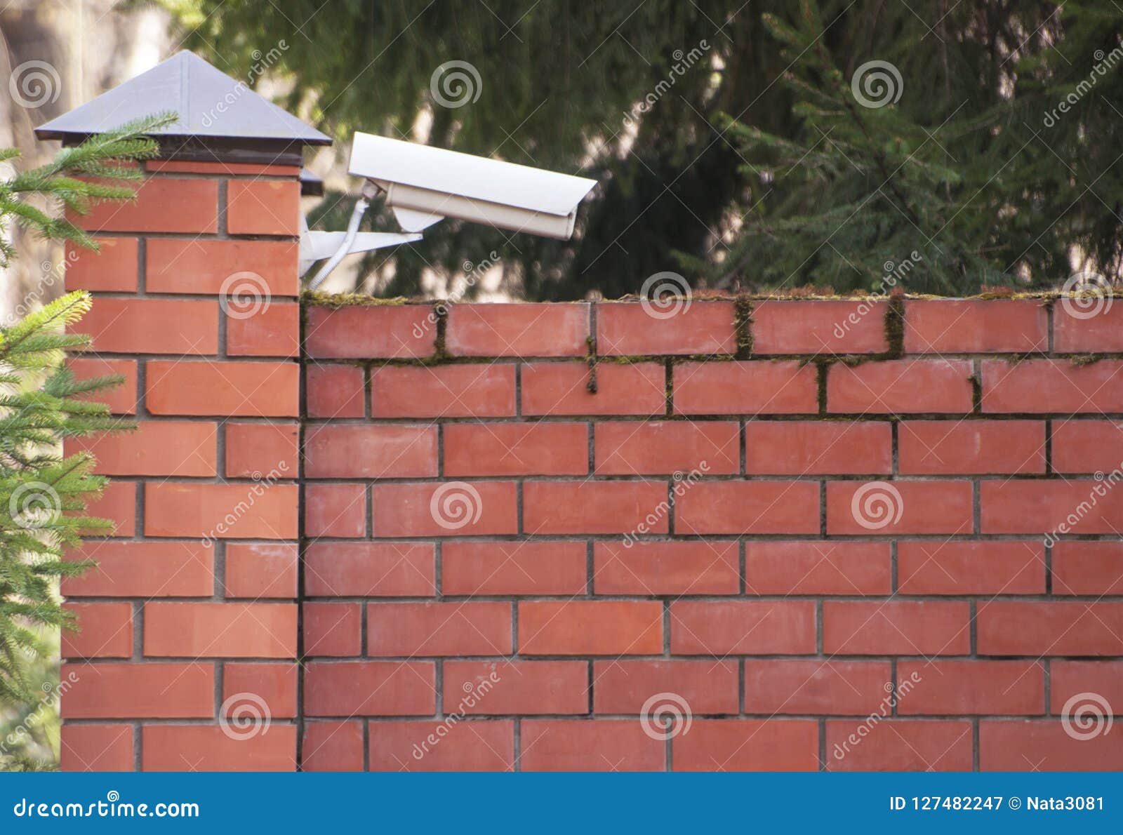 An External Surveillance Camera Over a Brick Fence of Private Property ...
