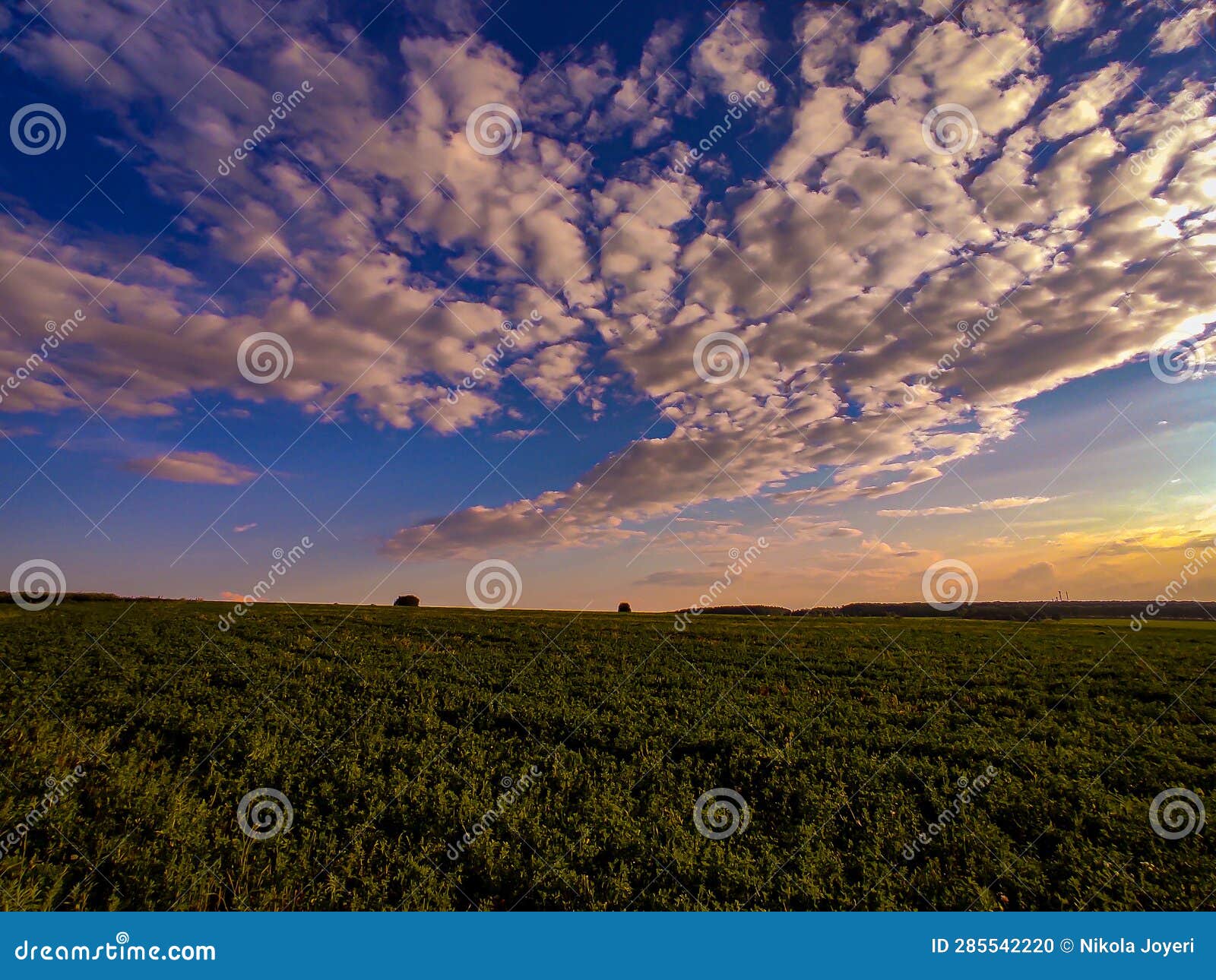 An Extraordinary Sunset on a Field with Floating Clouds Stock Photo ...