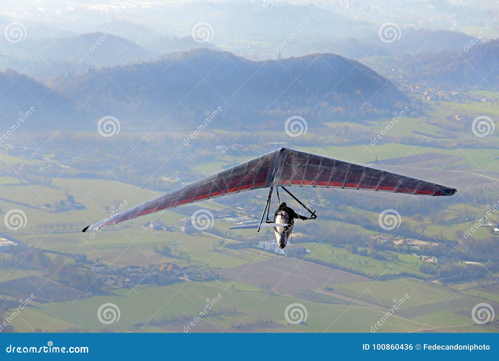 Man Flying High with His Hang Glider Above the Plain Stock Photo ...