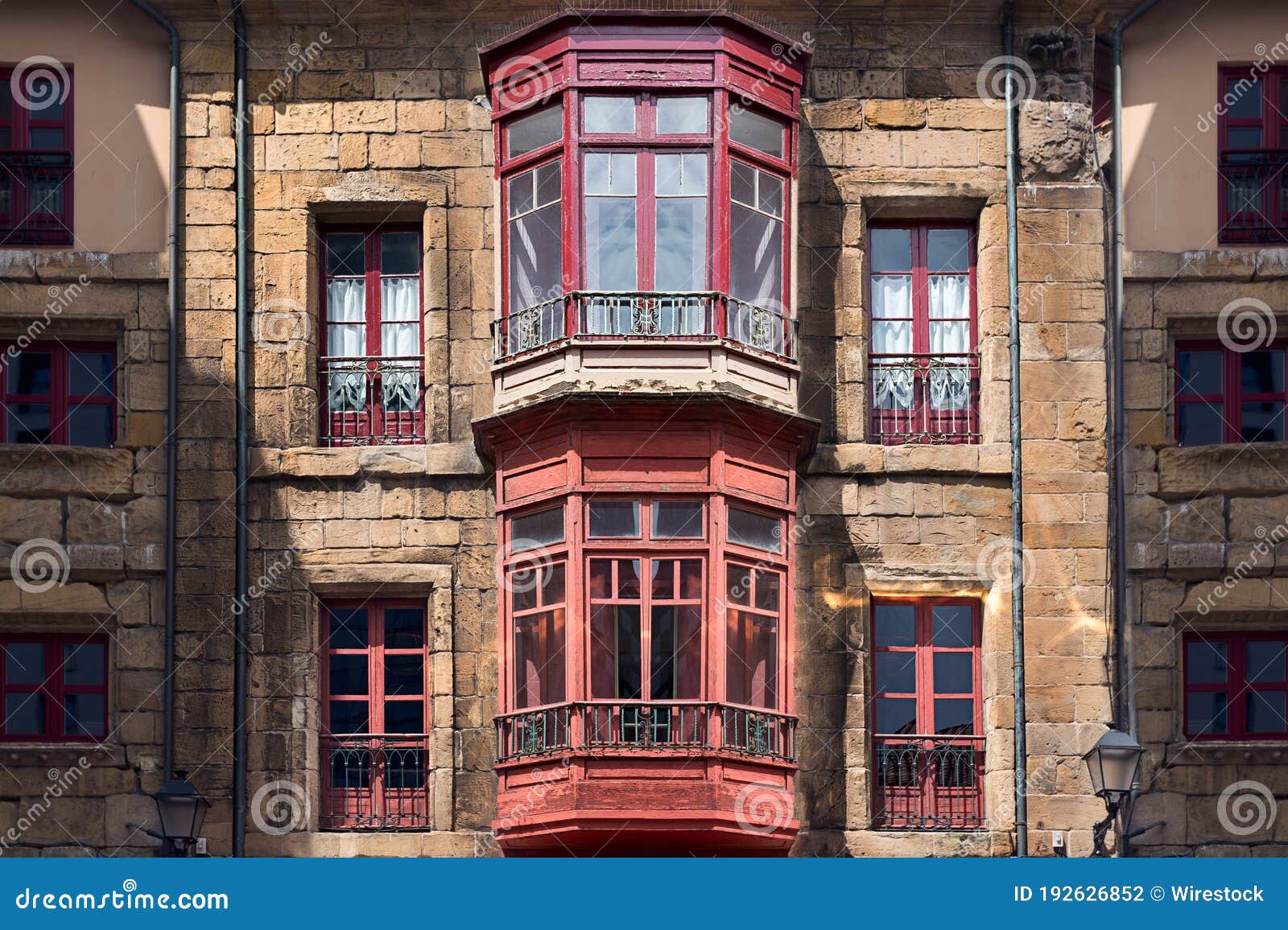Eye-level Shot of the Facade of a Stone Building with Red Windows and ...