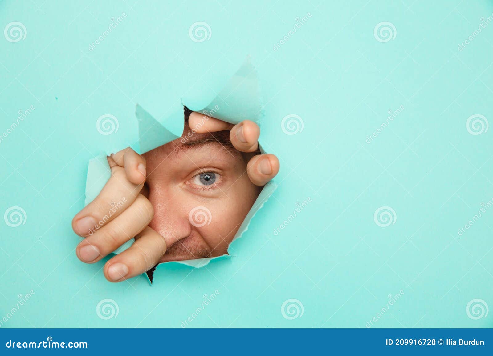 Eye Looking through Hole in Paper. Man Looking through Hole in Blue ...