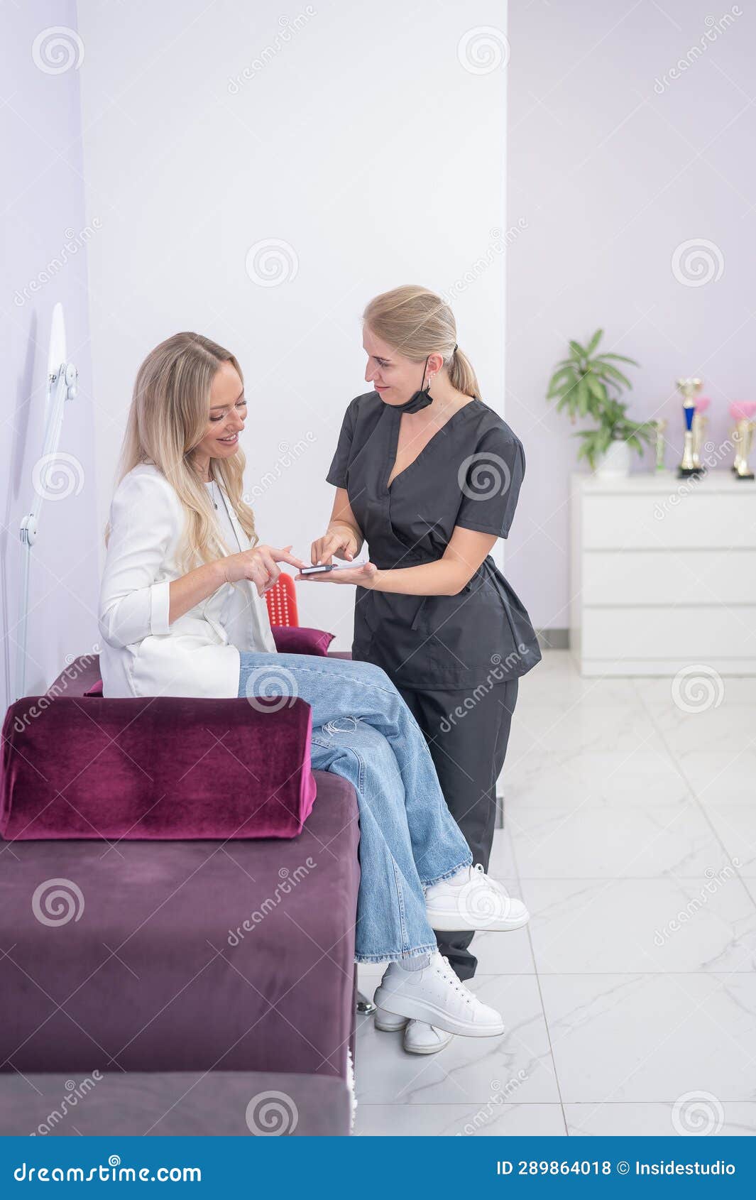 Eyelash Extension Master Shows Examples To a Client. Woman Choosing ...