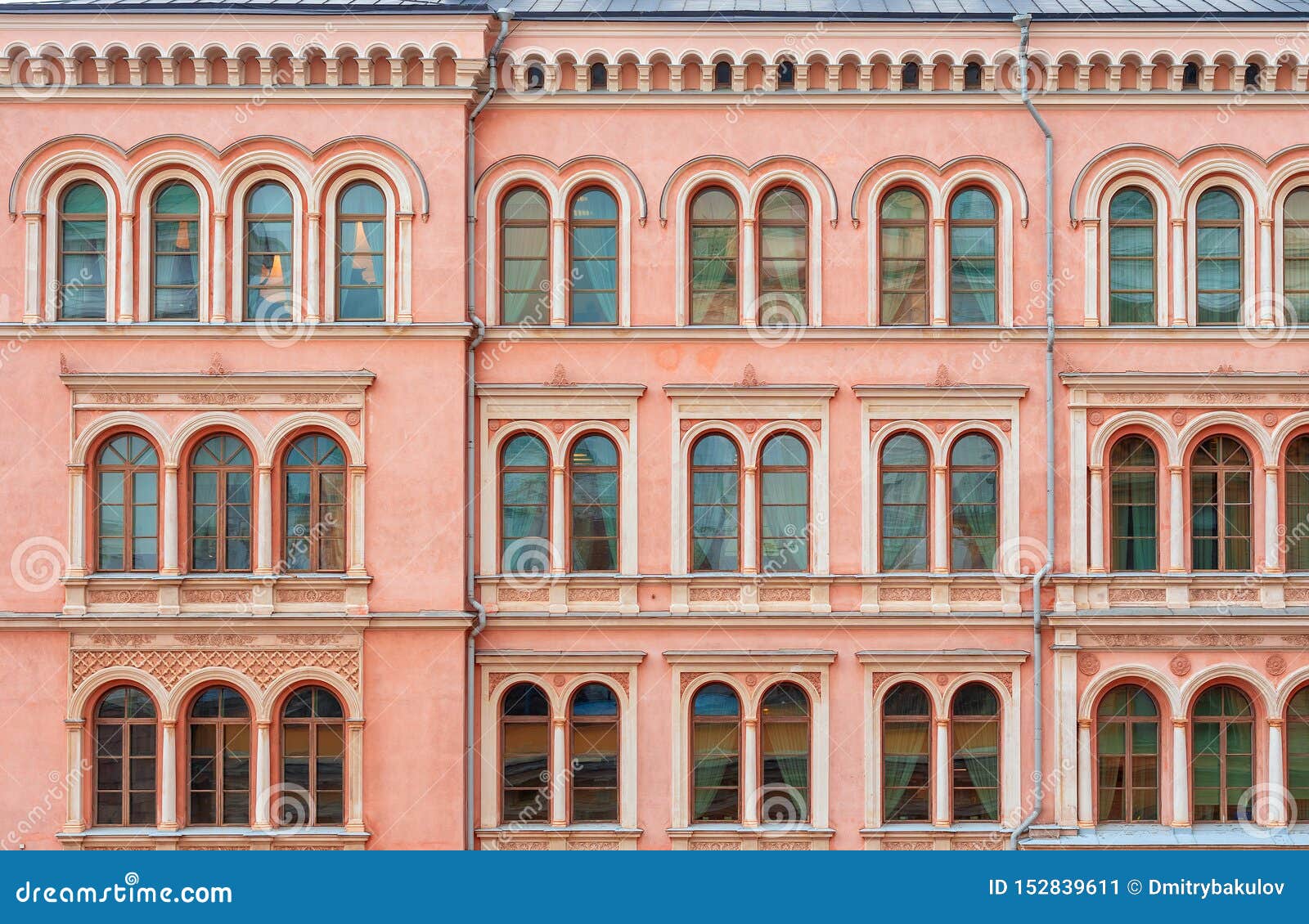 The Facade Of A Beautiful Pink City Building. Windows With Semicircular ...
