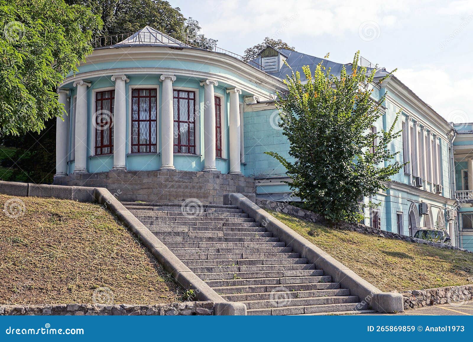 Facade of a Blue Old Building with White Stone Columns and Red Windows ...