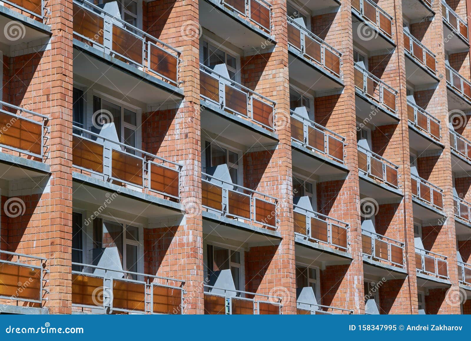 The Facade of a Brick Building with Several Rows of Balconies or ...