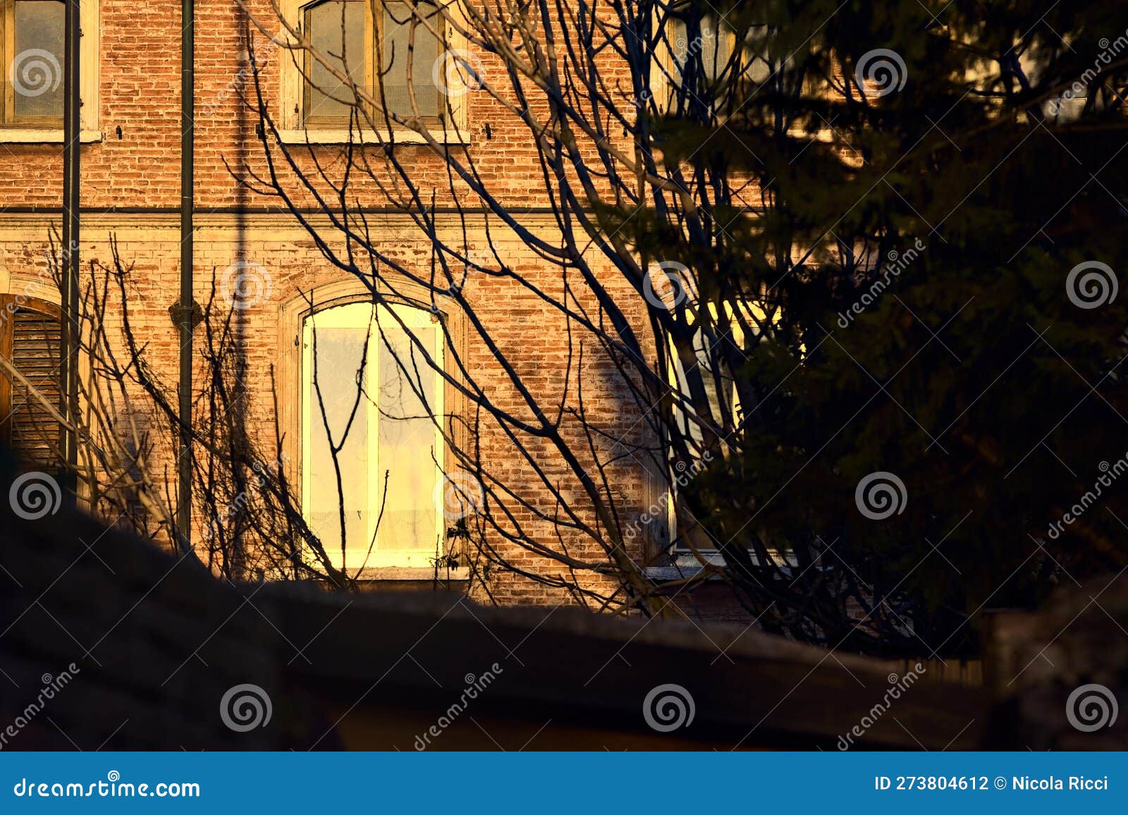 Facade of a Building with a Window Lit by the Sun at Twilight Stock ...