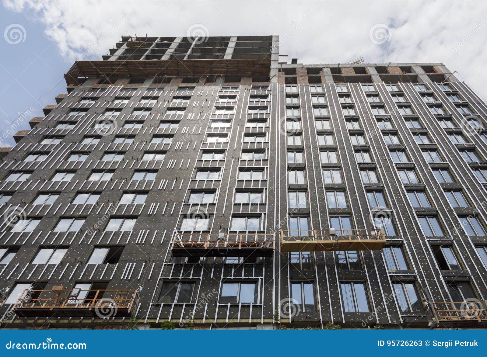 Facade of a High-rise Building Under Construction Against a Blue Sky ...