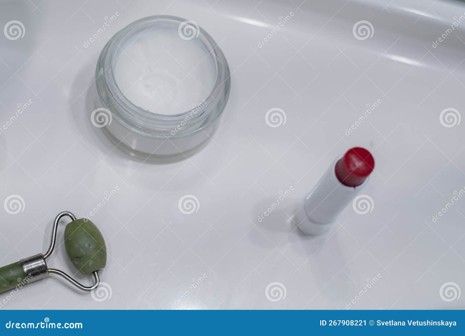 Face Cream, Face Roller and Lipstick Near the Sink on the Counter in ...