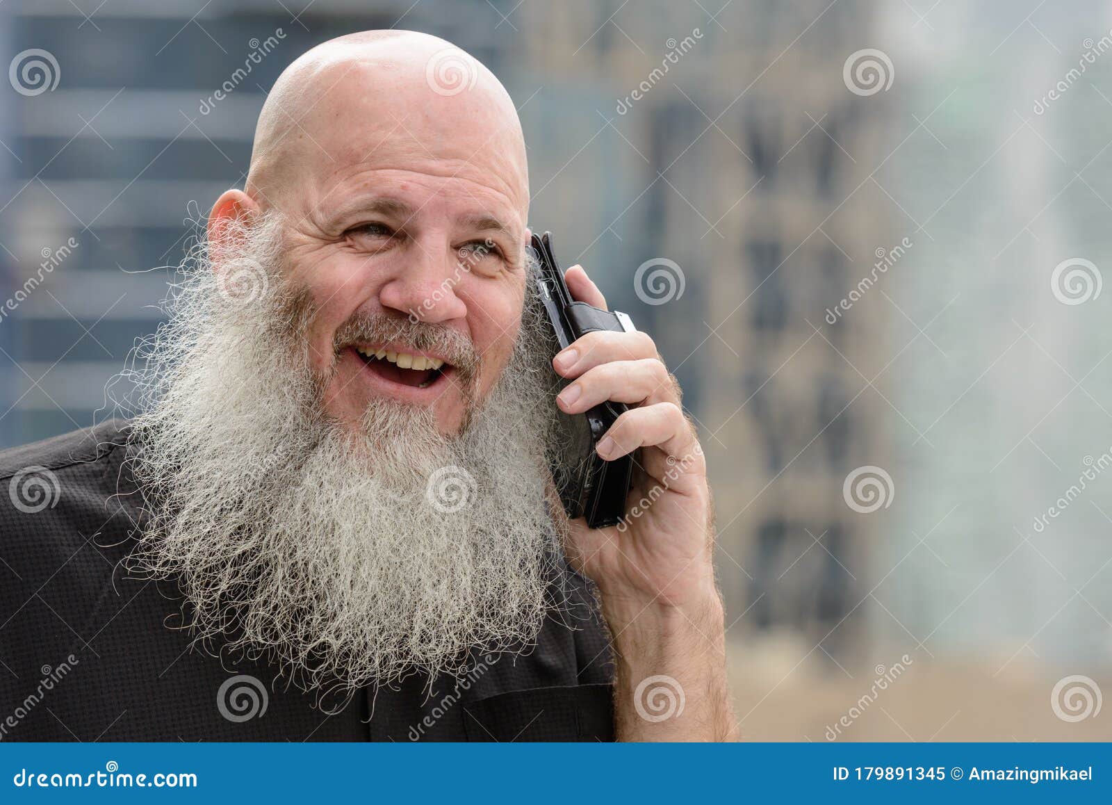Face Of Happy Mature Bald Bearded Man Talking On The Phone In The City