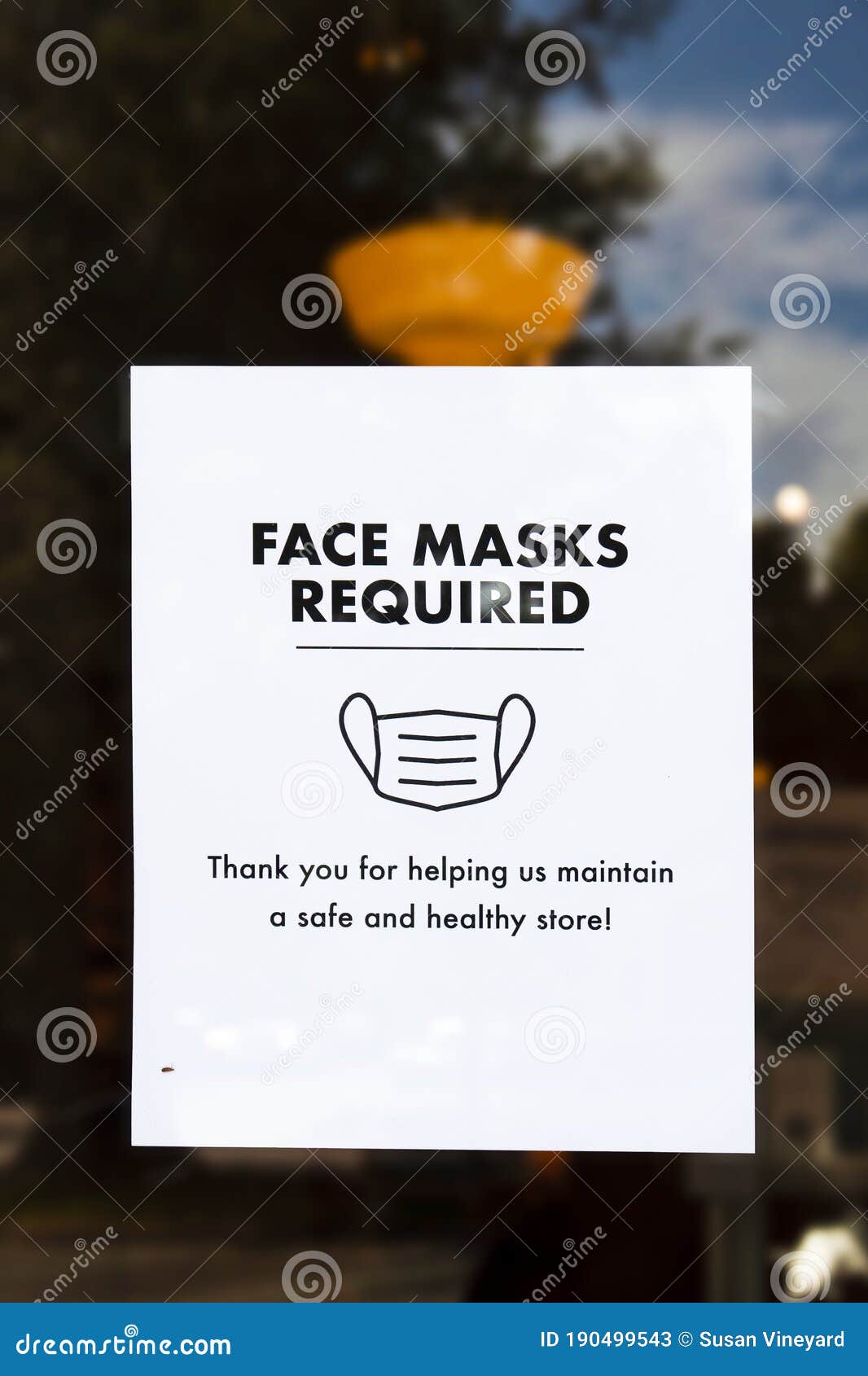 Face Mask Required Sign on Door of Store with Reflection of Sky and ...