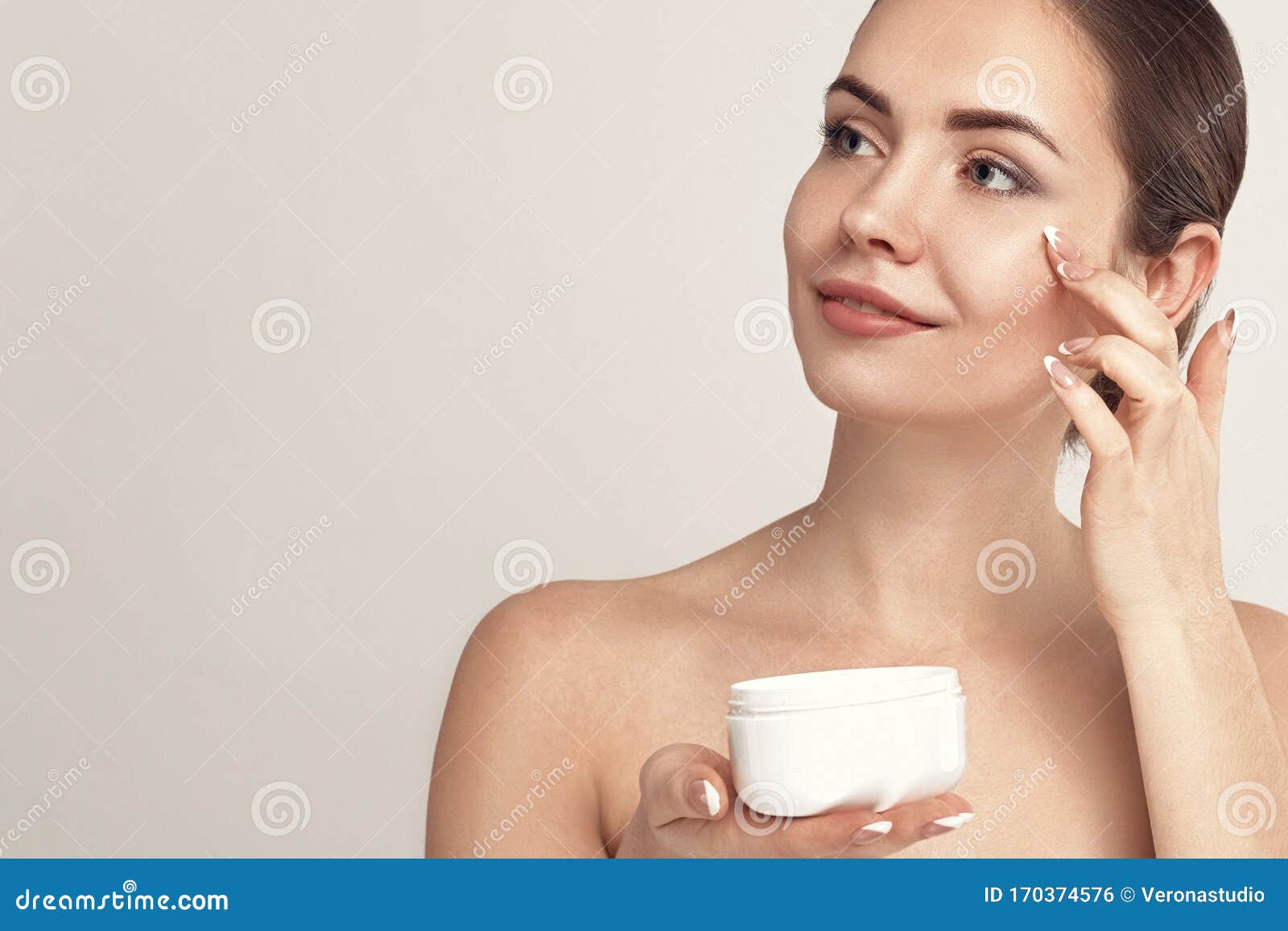 Facial Care Female Applying Cream And Smiling Portrait Of Young Woman