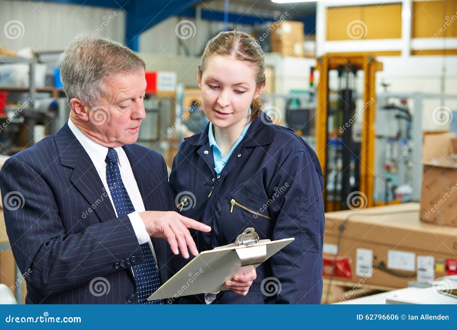 Factory Manager and Apprentice Engineer Looking at Clipboard Stock ...