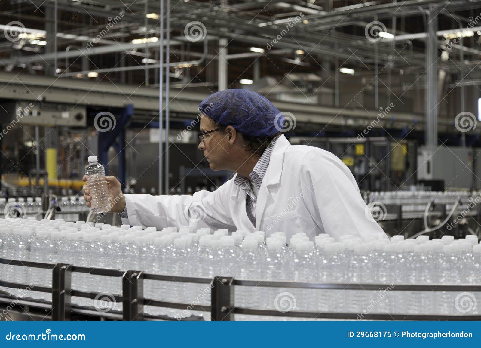 Factory Worker Examining Bottled Water Stock Photo - Image of machinery ...