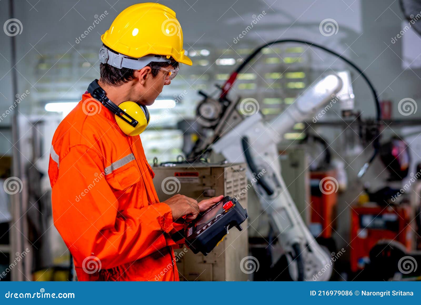 Factory Worker Man Hold Controller To Control Metal Welding Robotic ...