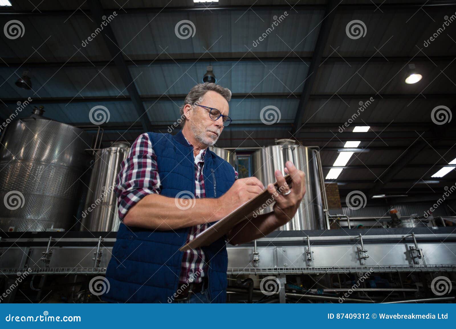 Factory Worker Writing on Clipboard in Factory Stock Photo - Image of ...
