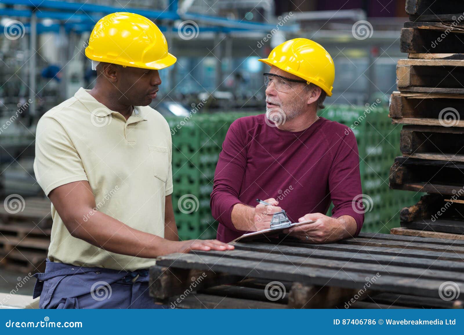 Factory Workers Discussing with a Clipboard in Drinks Production Plant ...