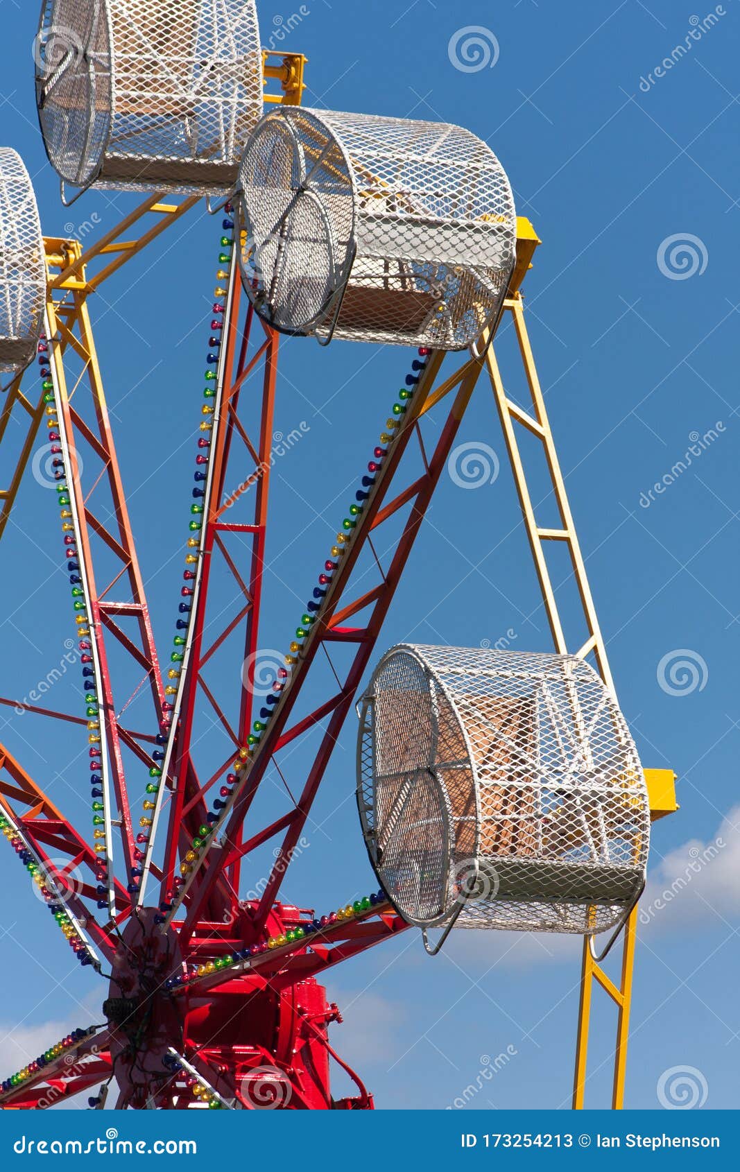 Fairground Wheel with Caged Chairs Against a Blue Sky Stock Image ...