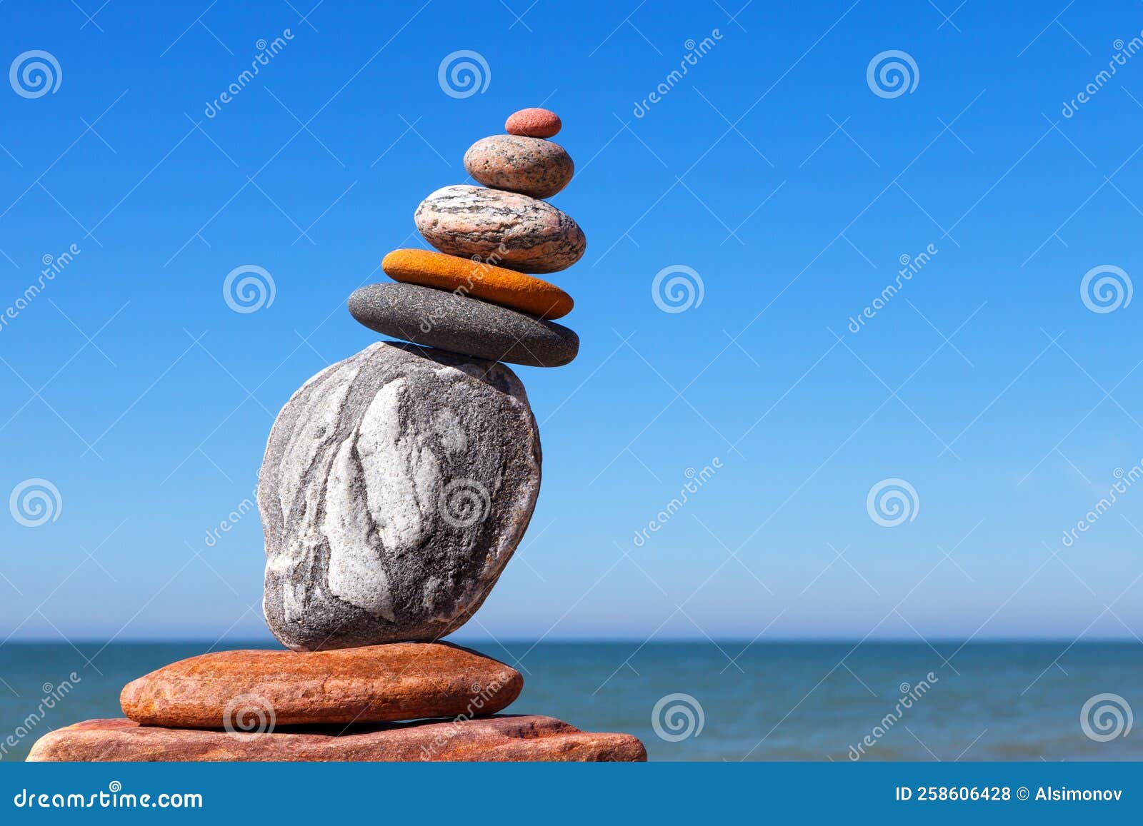The Fall of the Pyramid of Balanced Stones on Blue Sky Background Stock ...