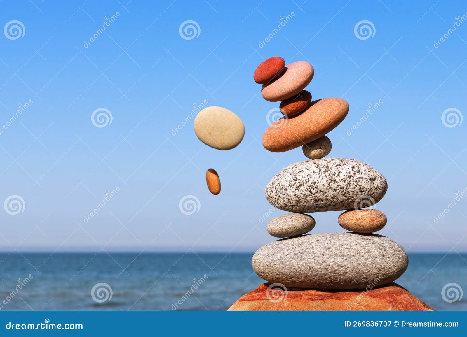 The Fall of the Pyramid of Balanced Stones on Blue Sky Background. the ...