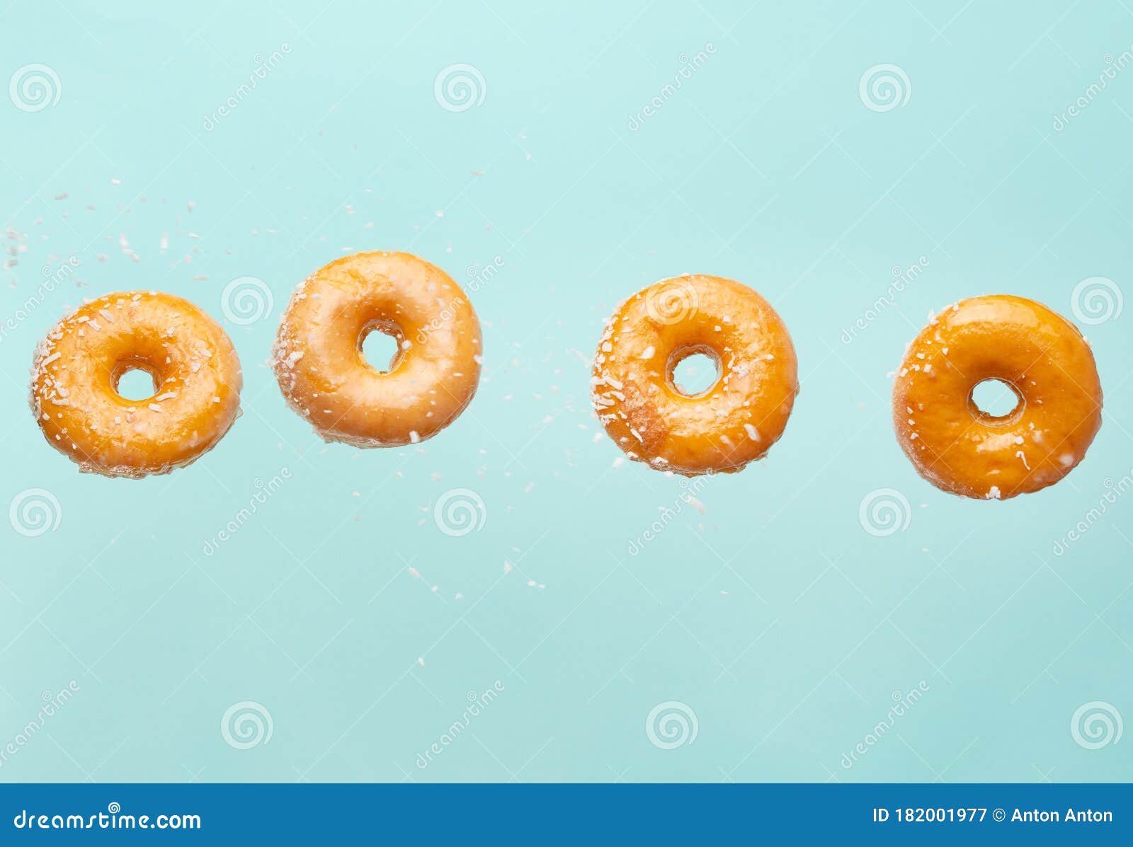 Falling Donuts with Coconut Flakes on a Light Blue Background. Freezing ...