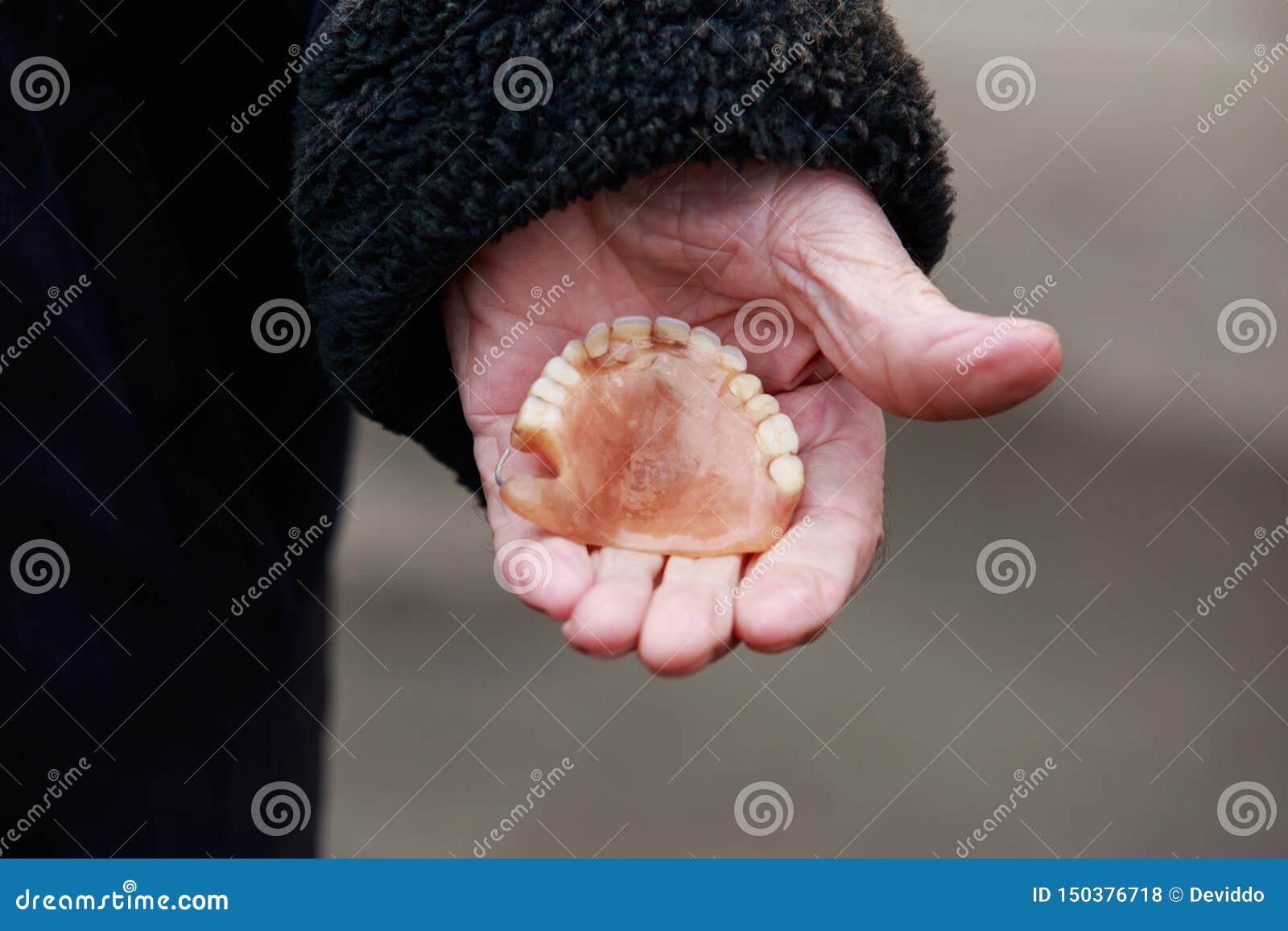 False teeth in old hands stock photo. Image of black - 150376718