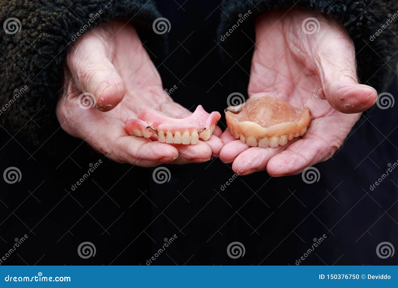 False teeth in old hands stock photo. Image of senior - 150376750