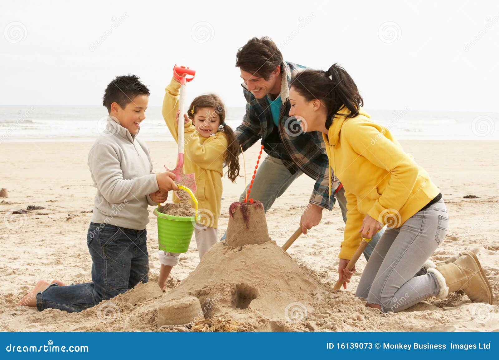 Family Building Sandcastle on Winter Beach Stock Image - Image of ...