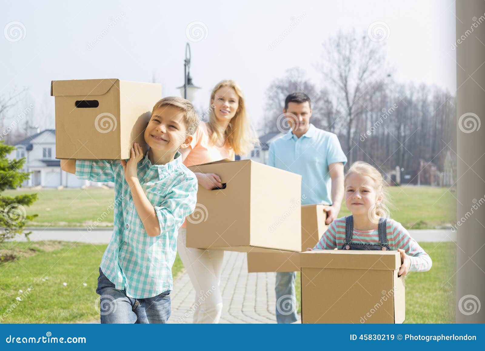 Family with Cardboard Boxes Moving into New House Stock Image - Image ...