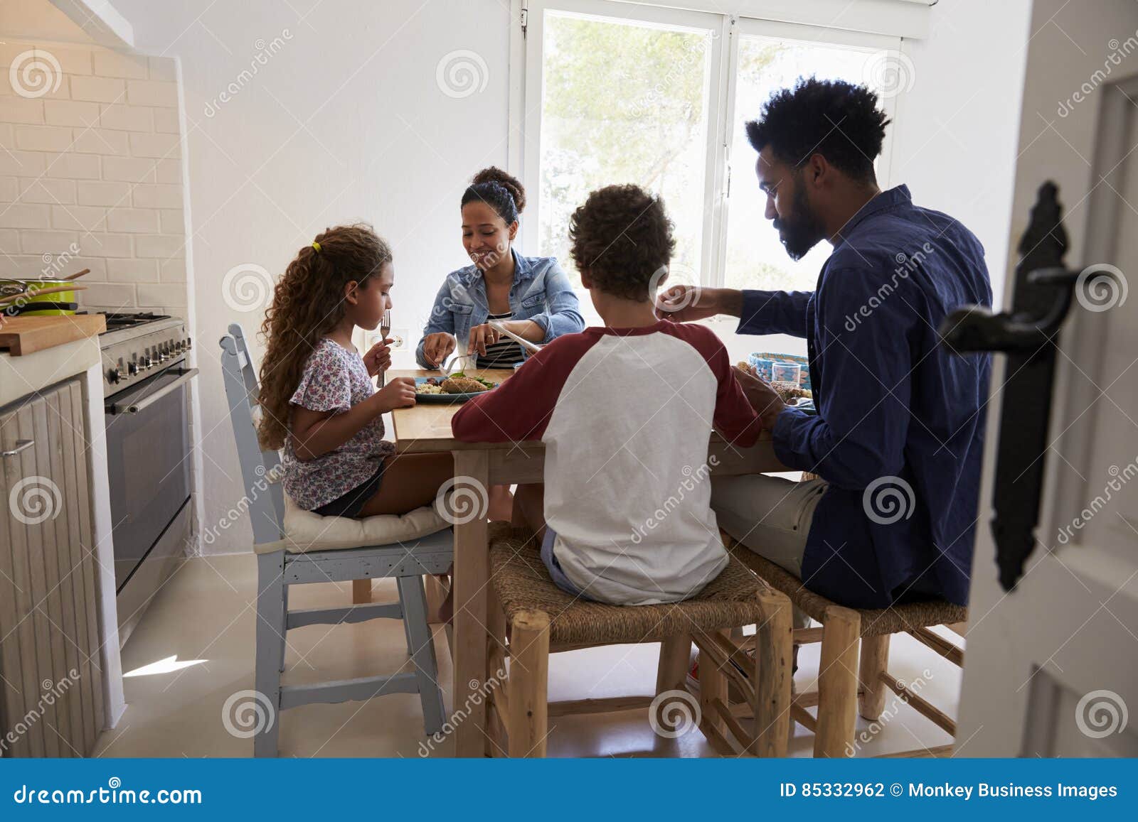 Family Eating at Kitchen Table, Back View, Seen from Doorway Stock ...