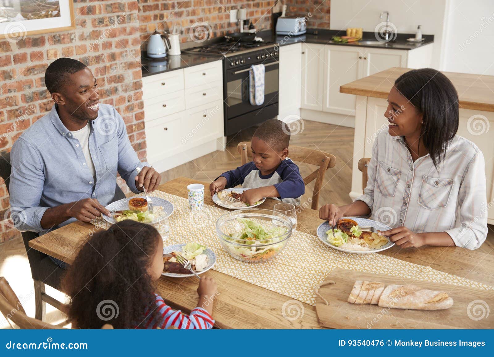 Family Eating Meal in Open Plan Kitchen Together Stock Photo - Image of ...