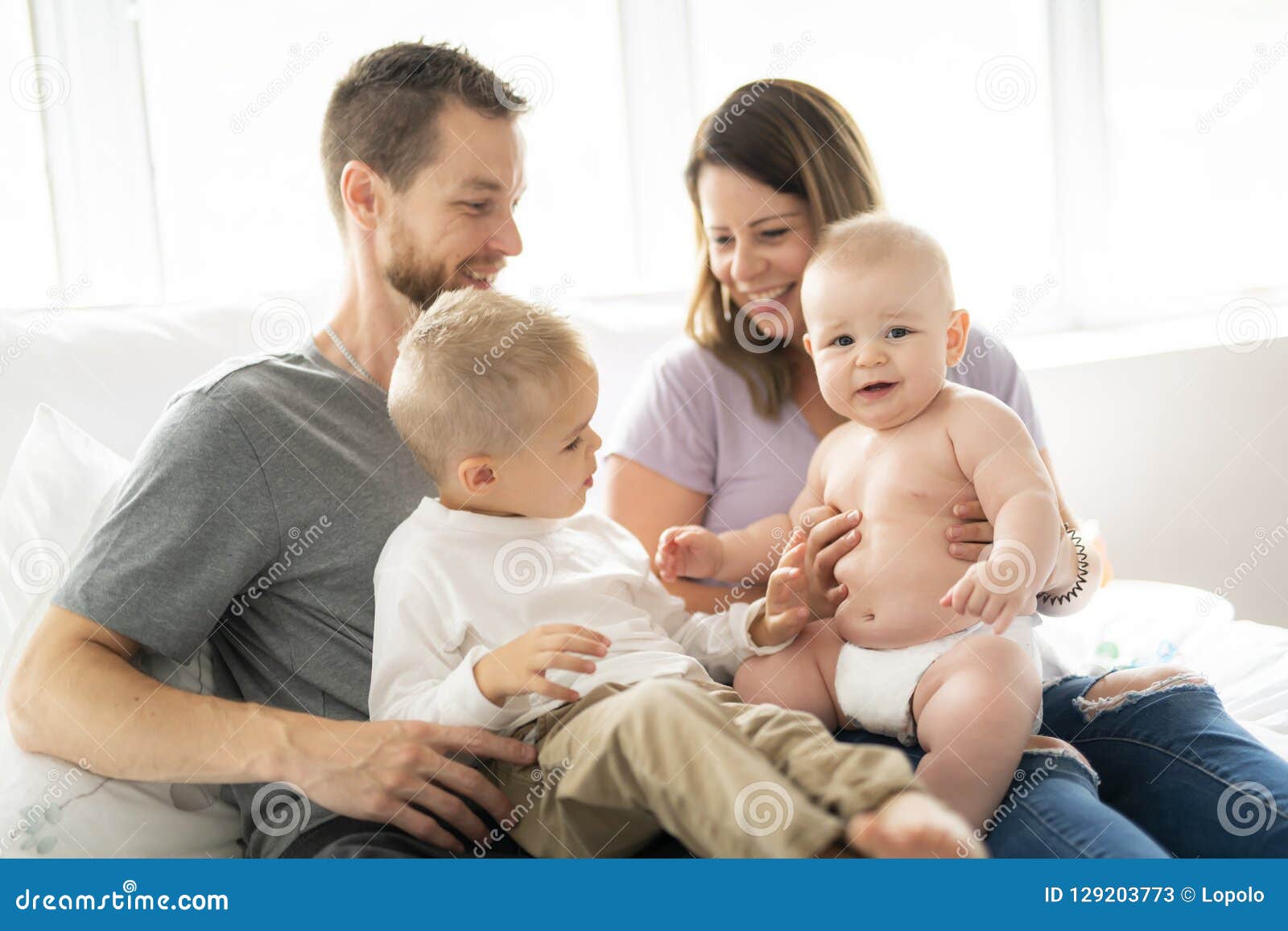 Family of Four with Baby Having Fun on Bed Stock Image - Image of ...