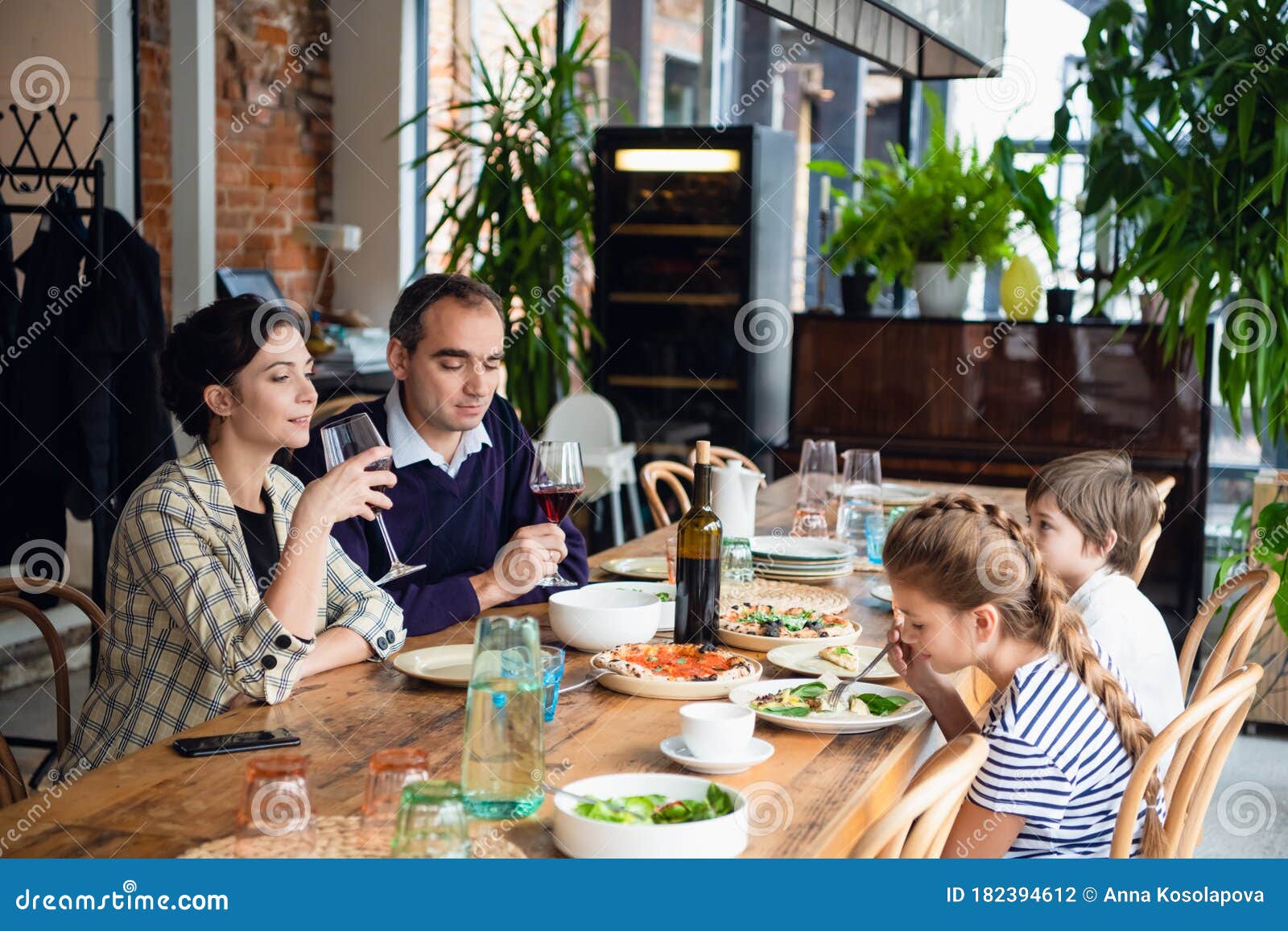 A Family of Four Having a Dinner in a Cafe Stock Photo - Image of ...