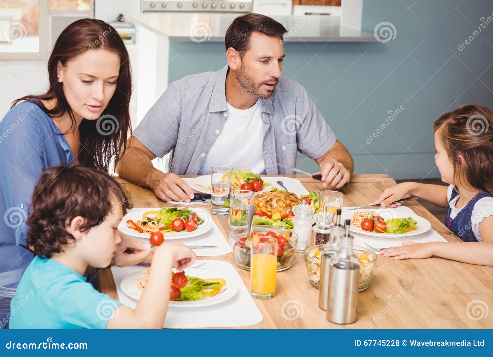 Family Having Lunch while Sitting at Dining Table Stock Photo - Image ...
