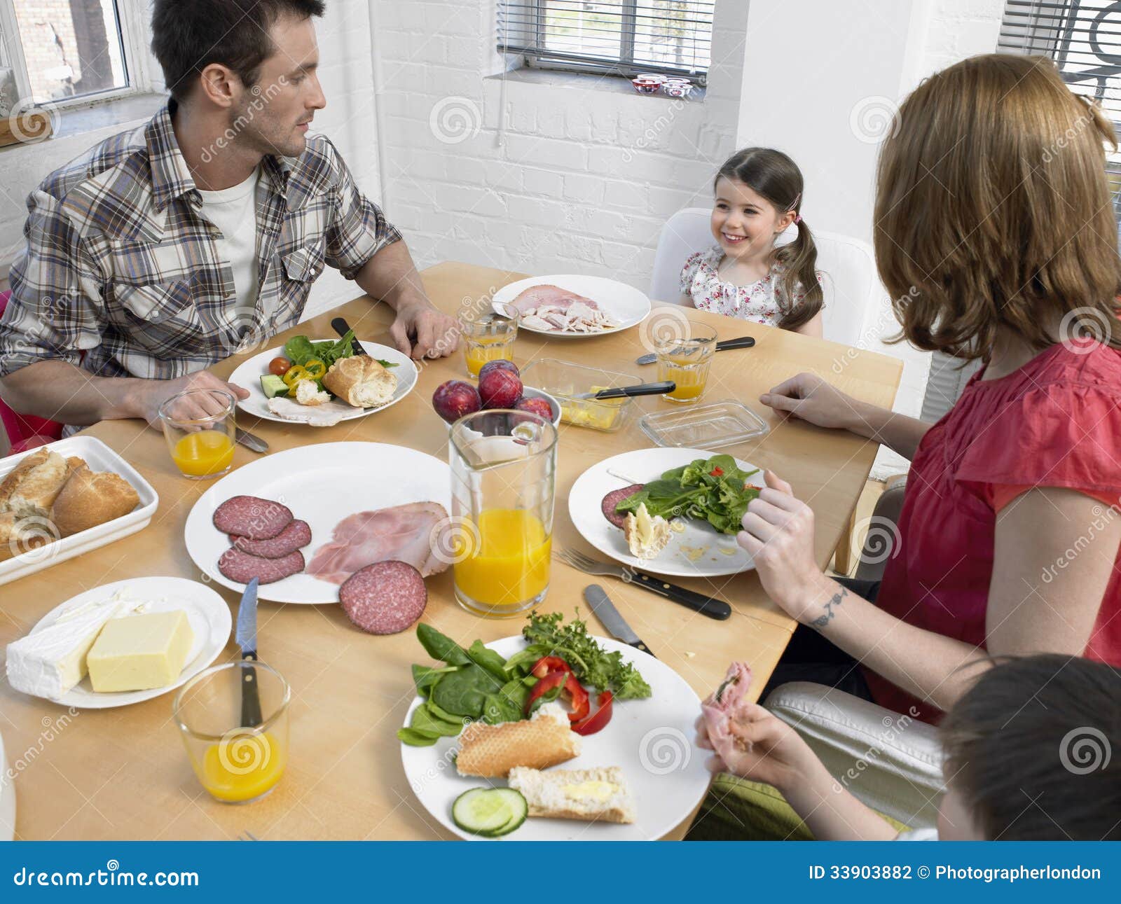 Family Having Meal at Dining Table Stock Photo - Image of holding ...