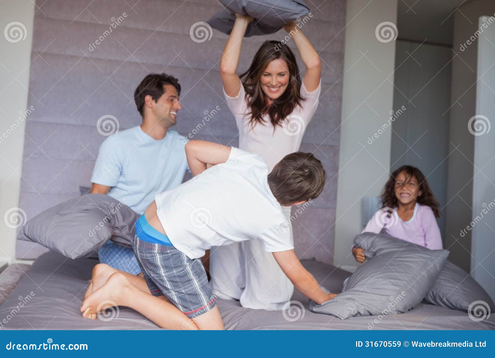 Family Having a Pillow Fight on the Bed Stock Image - Image of handsome ...