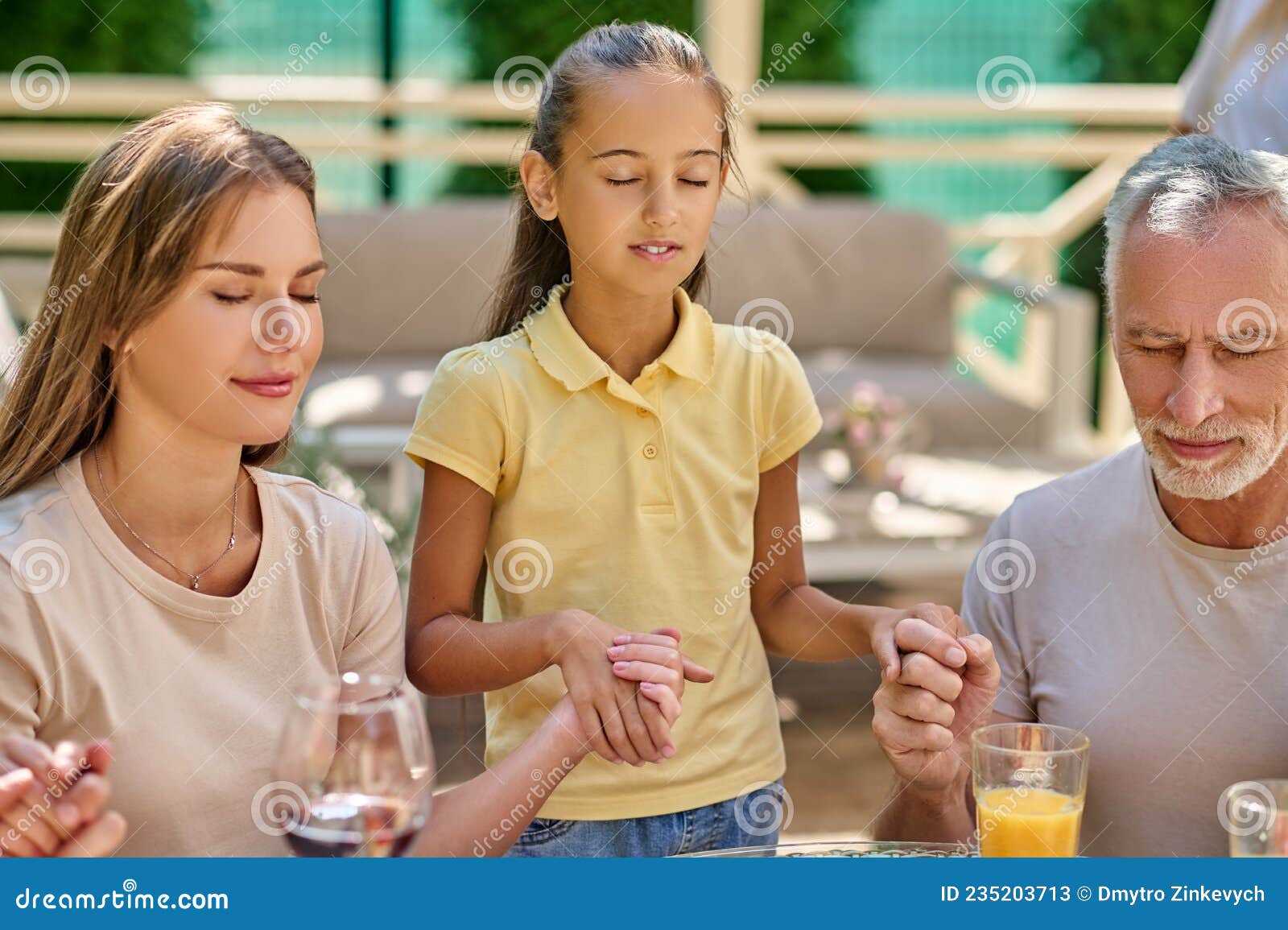 A Family Holding Hands and Praying before Dinner Stock Image - Image of ...