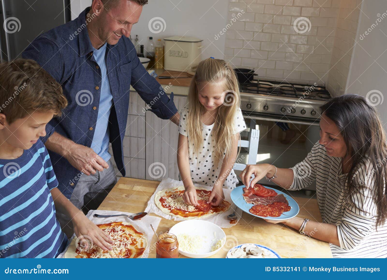Family at Home in Kitchen Making Pizzas Together Stock Image - Image of ...