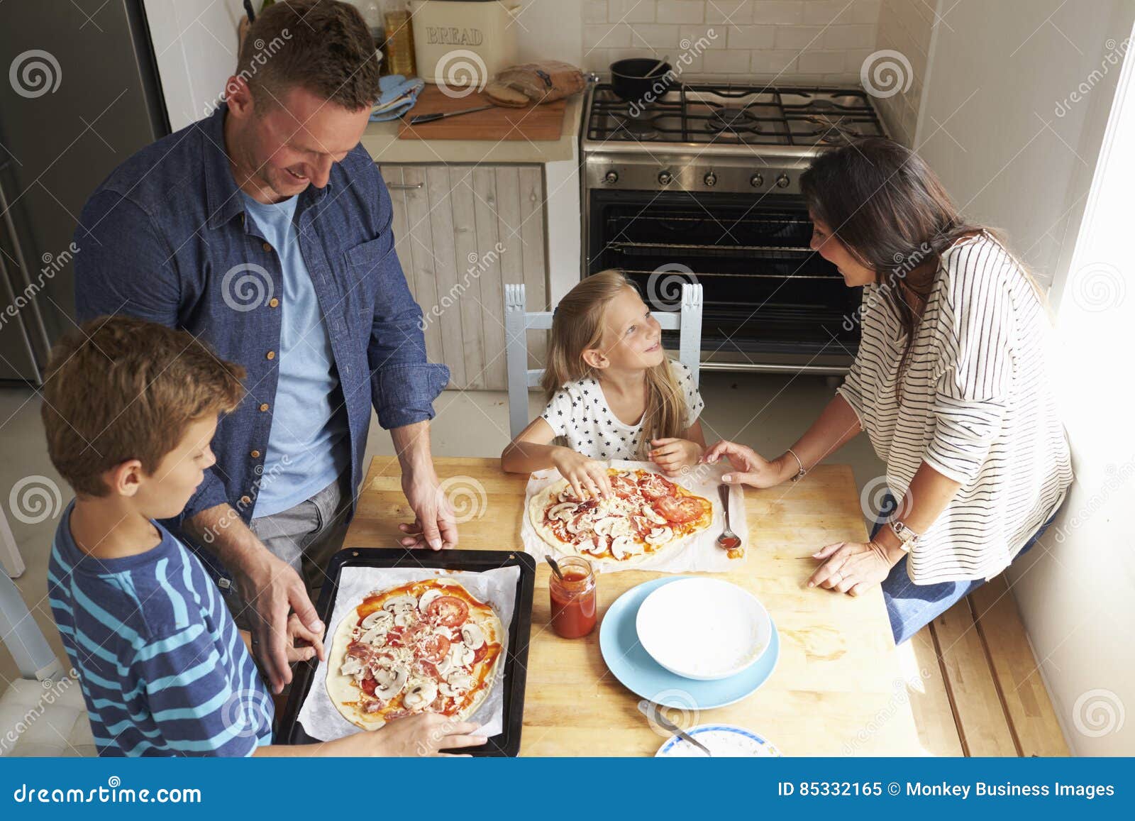 Family at Home in Kitchen Making Pizzas Together Stock Image - Image of ...