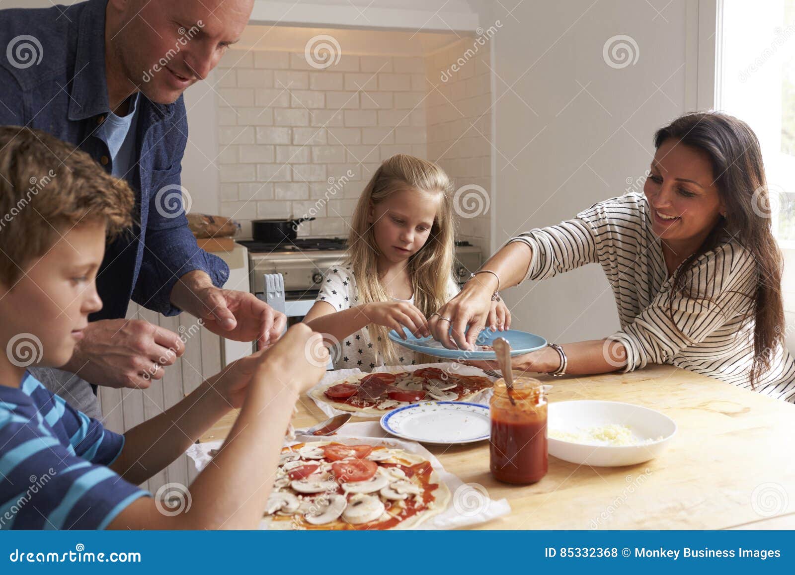 Family at Home in Kitchen Making Pizzas Together Stock Photo - Image of ...