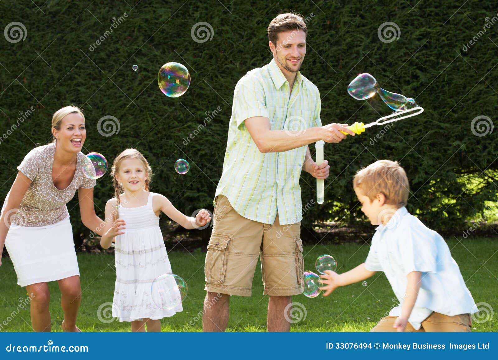 Family Playing with Bubbles in Garden Stock Photo - Image of child ...