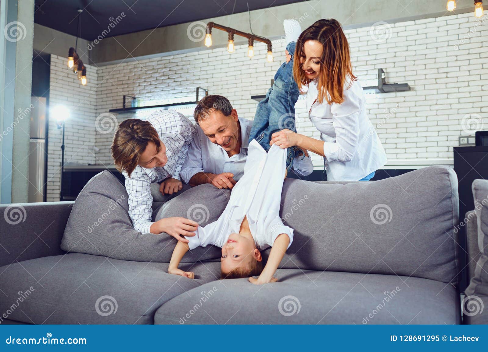 A Family is Playing on the Couch in the Room. Stock Image - Image of ...