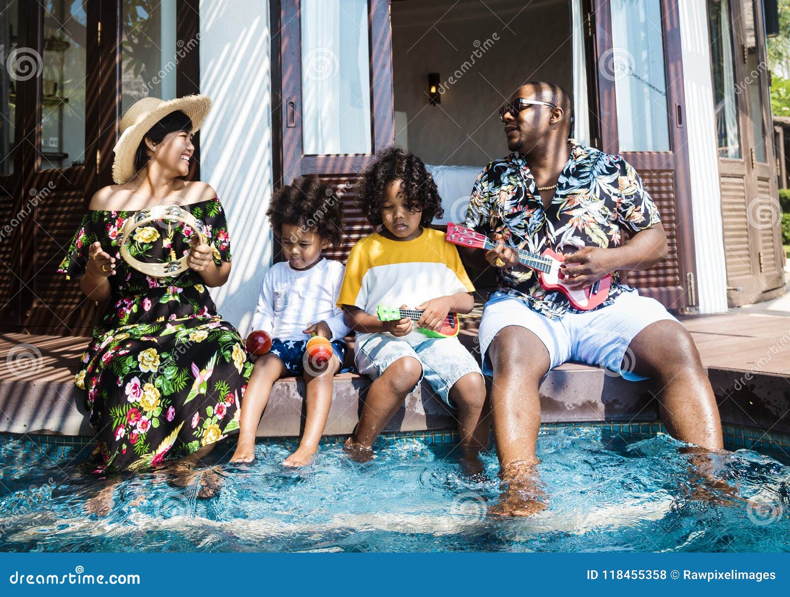 Family playing in a pool stock photo. Image of luxury - 118455358
