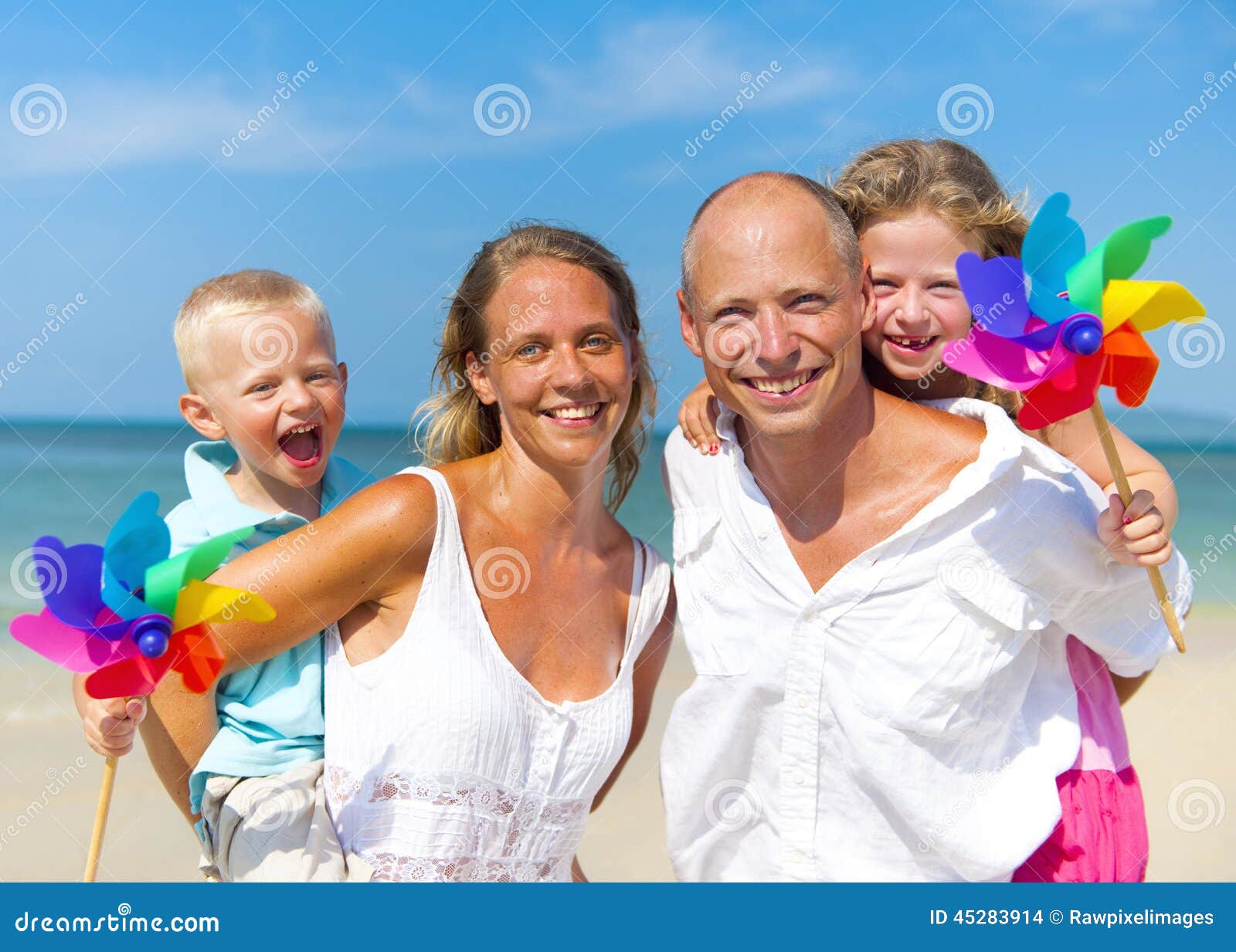 Family Playing with Windmill on Beach Stock Photo - Image of cheerful ...