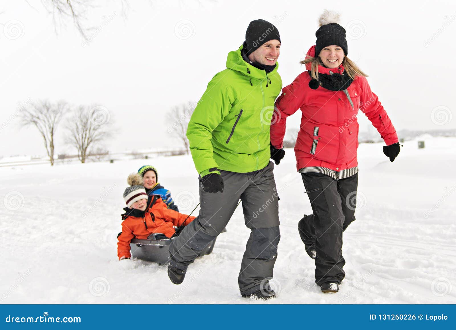 Cute Family Pulling Sledge through Snowy Landscape Stock Photo - Image ...
