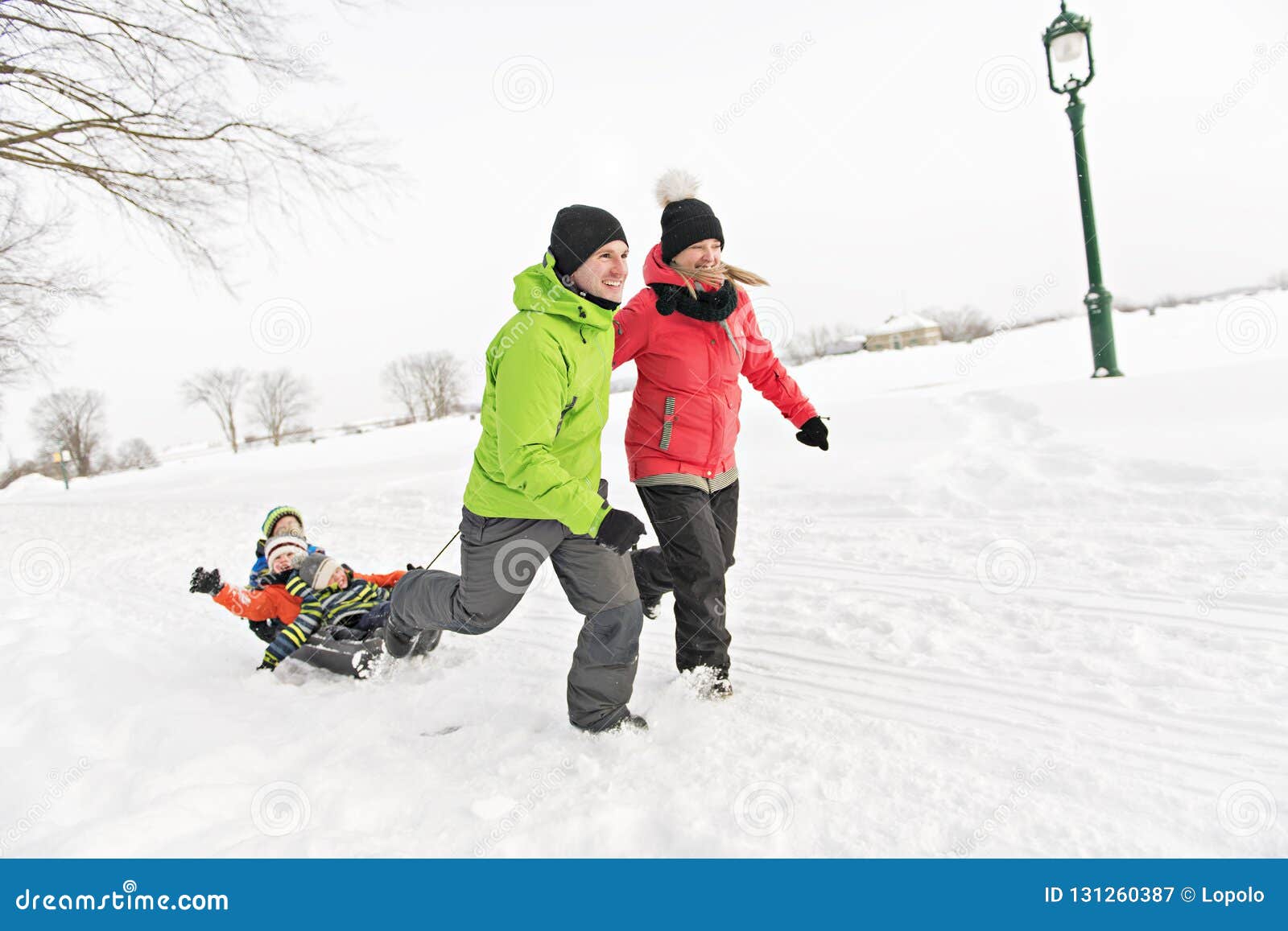 Cute Family Pulling Sledge through Snowy Landscape Stock Image - Image ...